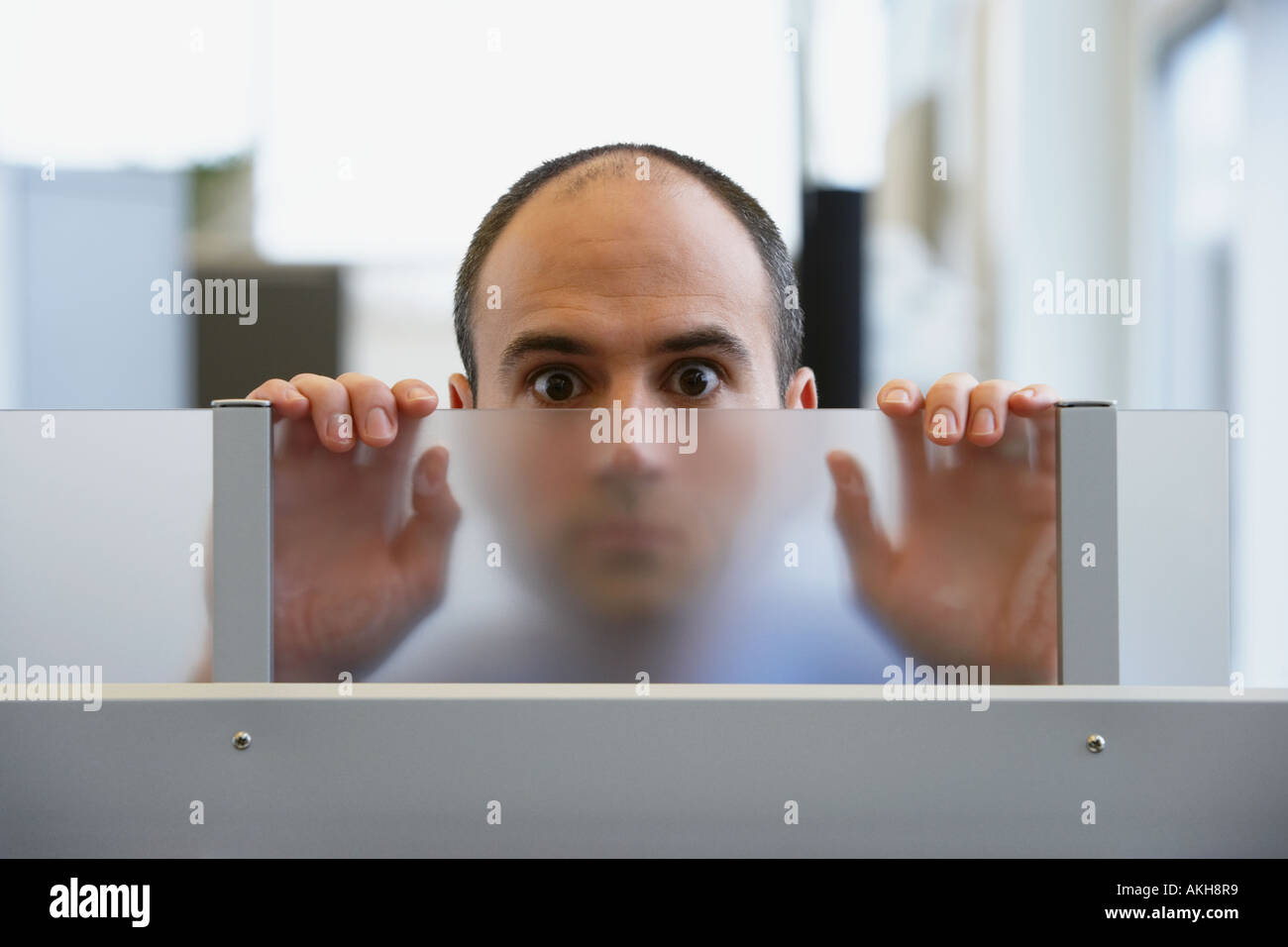 Man peering through a glass partition Stock Photo - Alamy