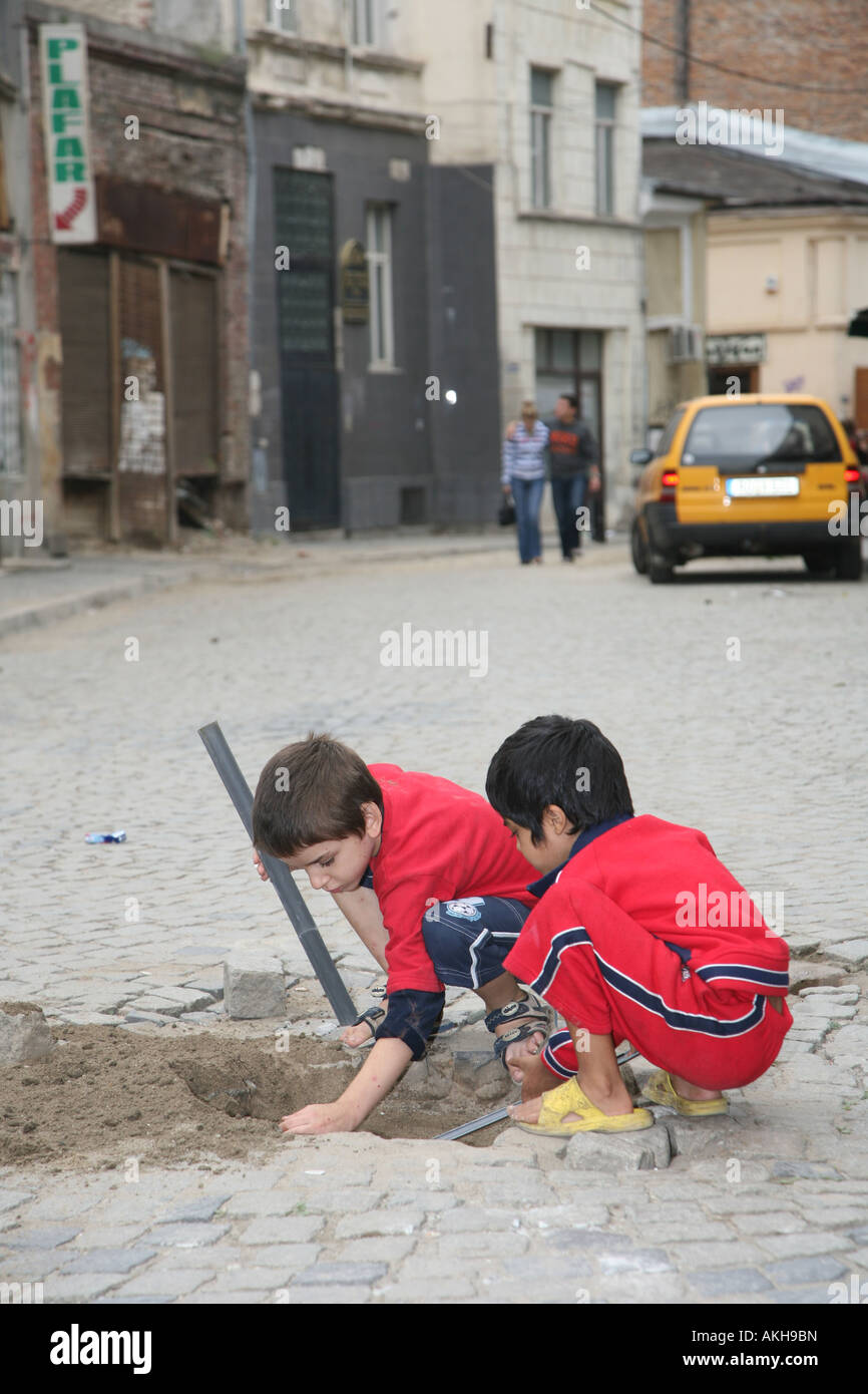Young boys dig hole in the road Lipscani district Bucharest Romania ...