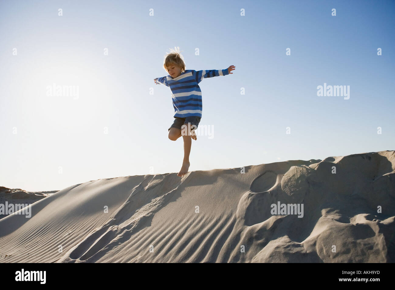 Boy jumping on sand dune Stock Photo - Alamy