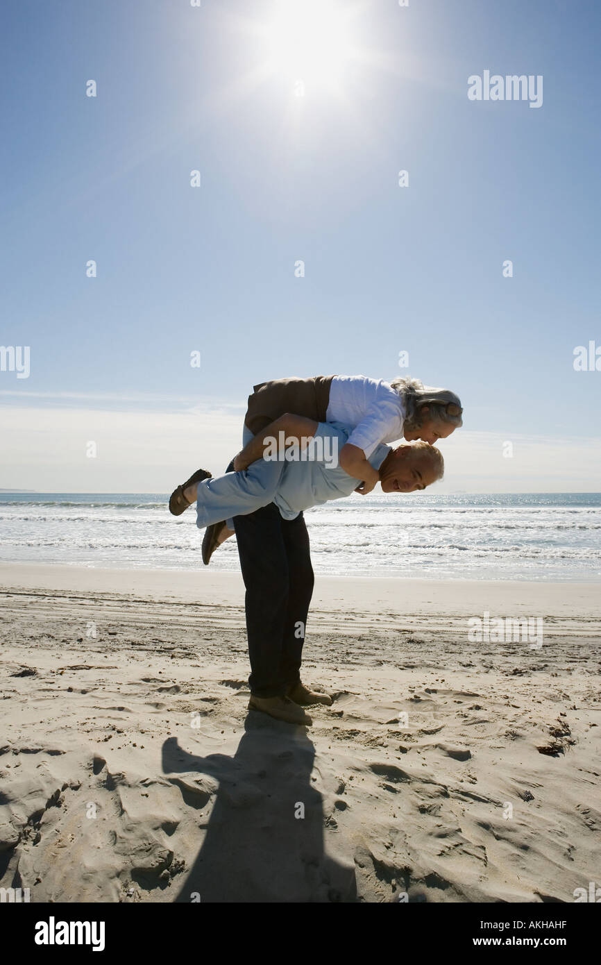 Senior man carrying woman on back Stock Photo - Alamy