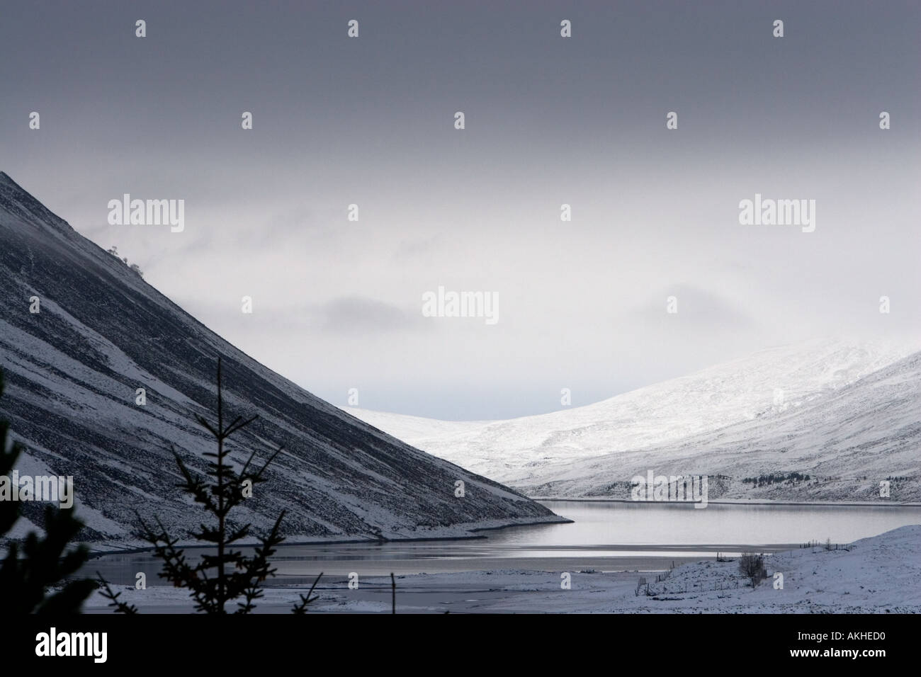 Scottish highlands in winter snow covered mountains and overcast sky in ...