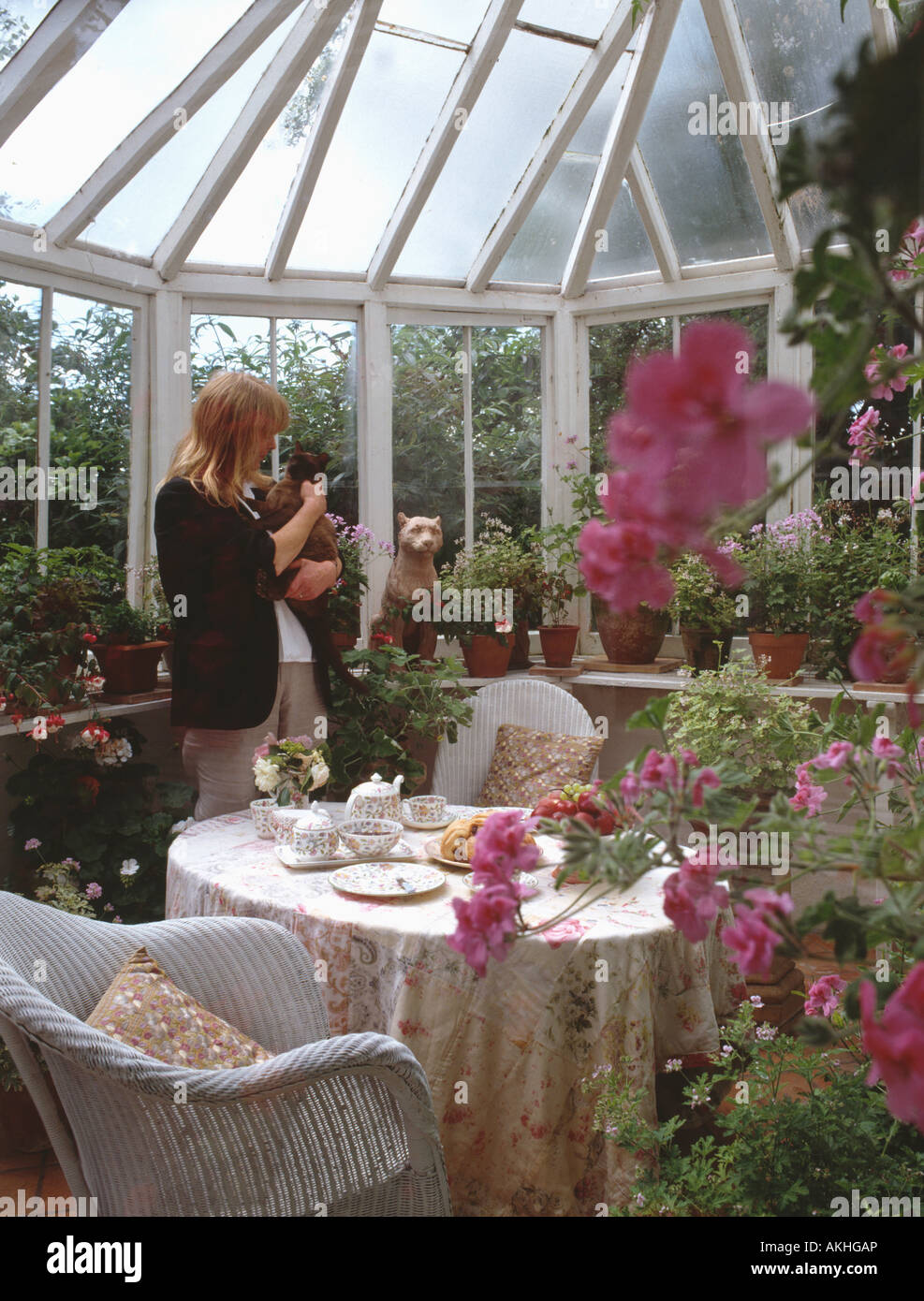 Woman holding a cat in conservatory FOR EDITORIAL USE ONLY Stock Photo ...
