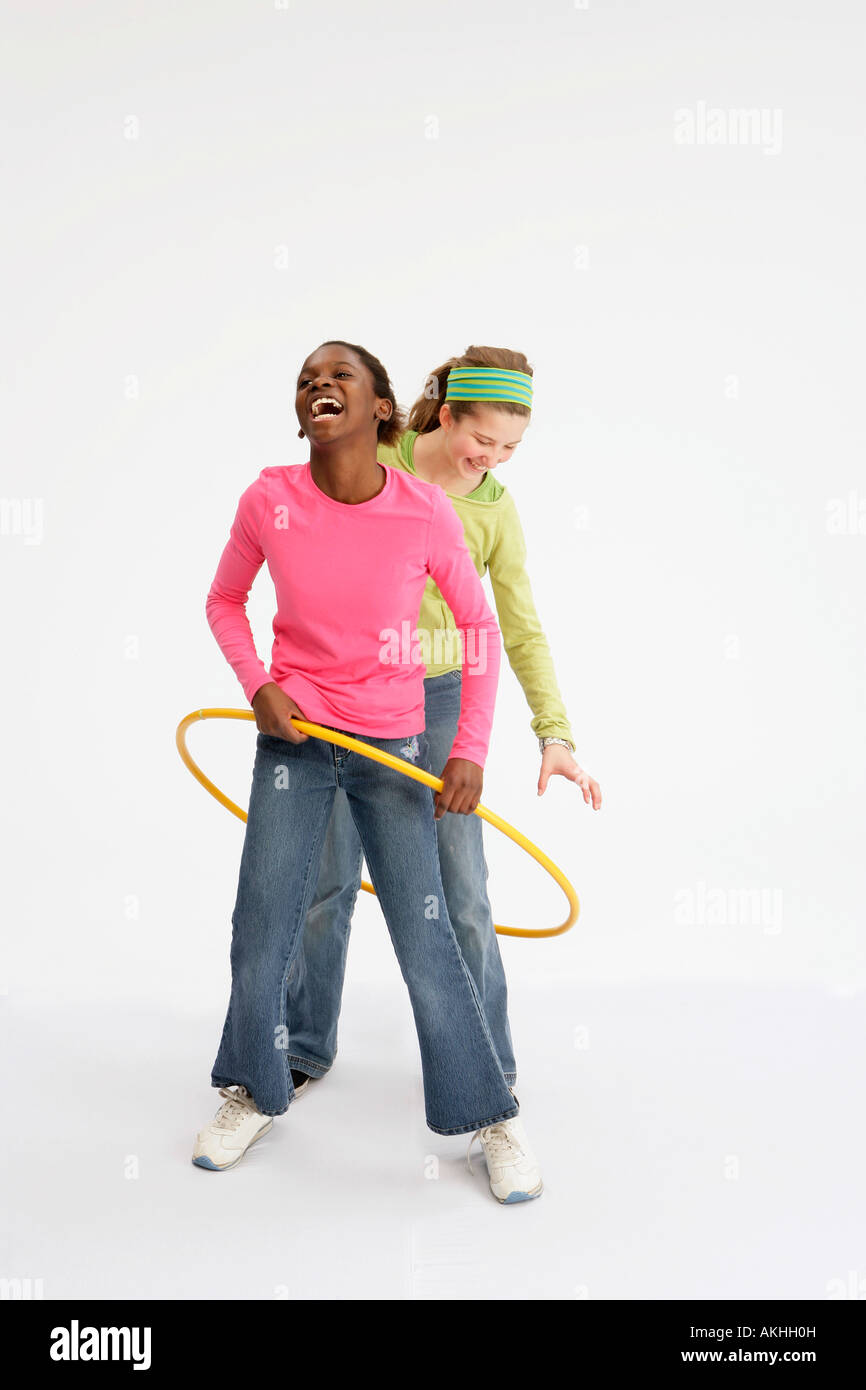 Two girls playing with hula hoop Stock Photo - Alamy
