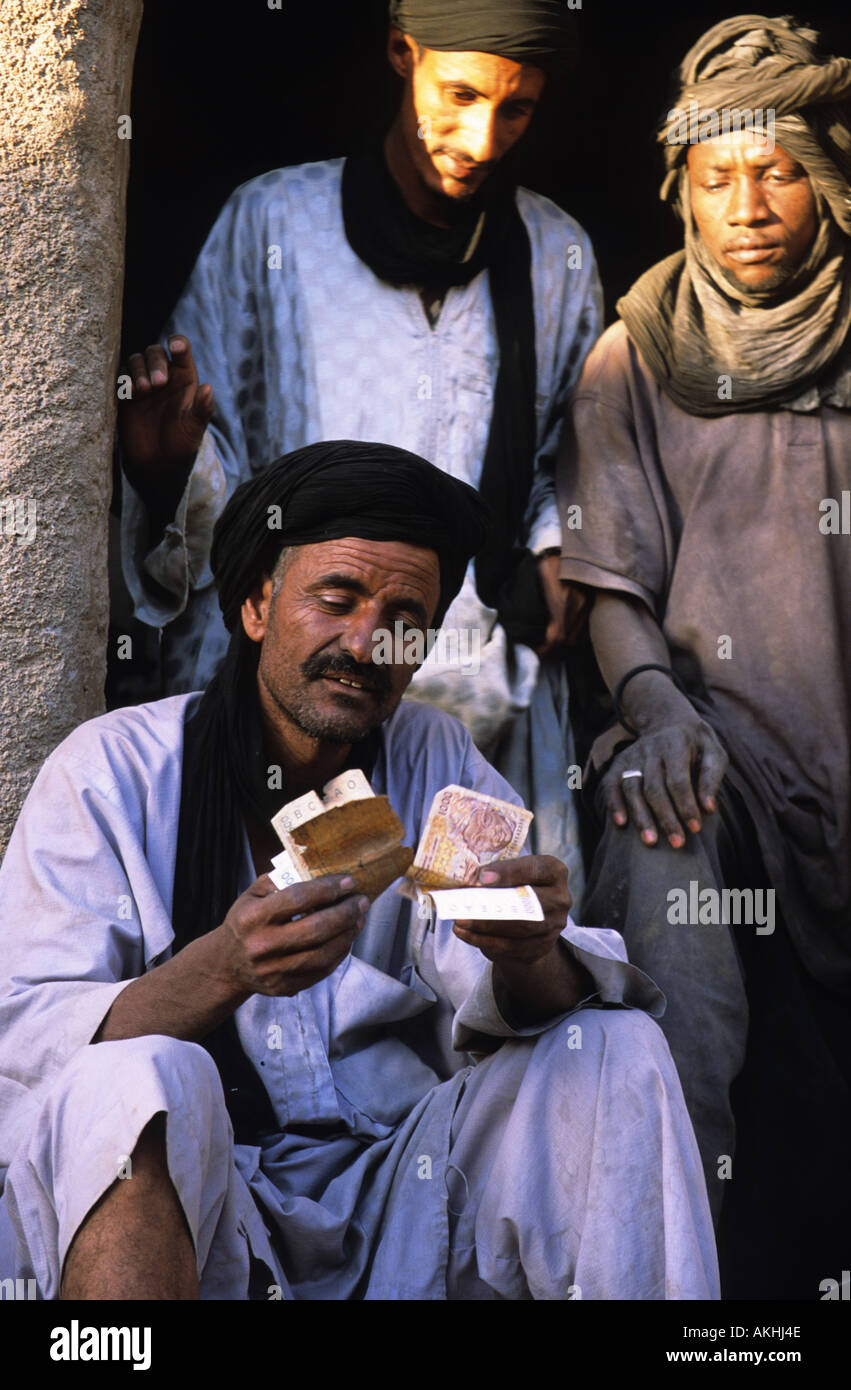 A market trader counts his money in the desert town of Kidal, Northern ...