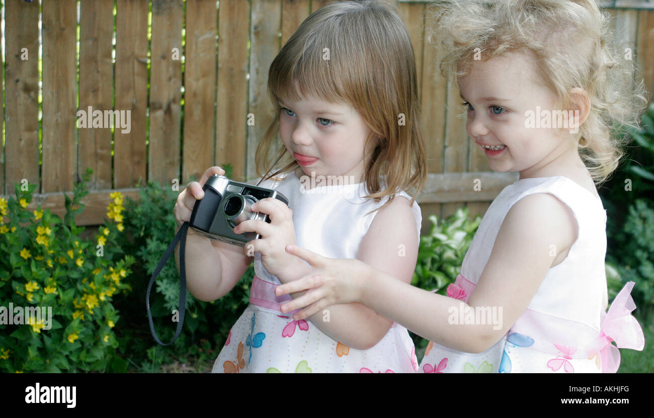 Two young girls using a digital camera to take photos Stock Photo - Alamy