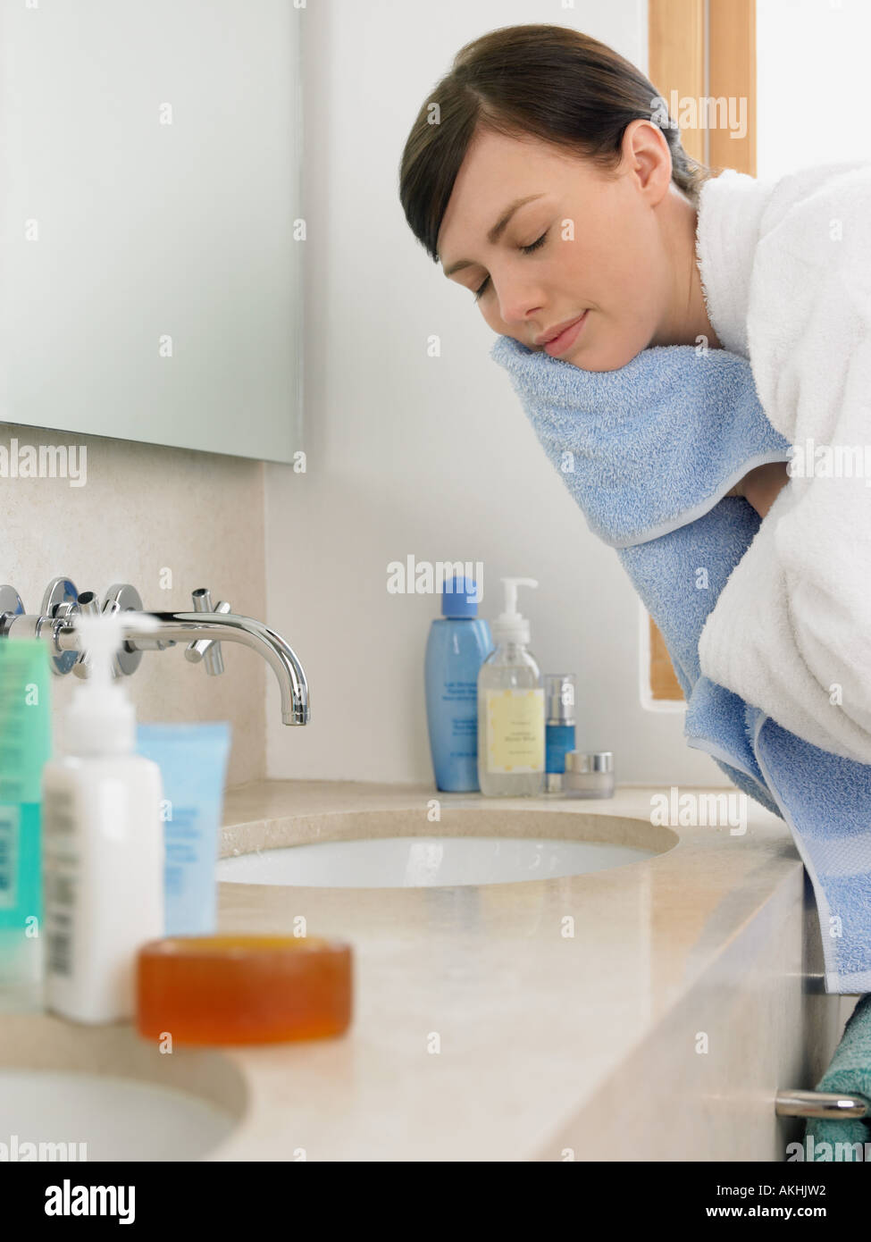 Woman drying her face in bathroom Stock Photo - Alamy