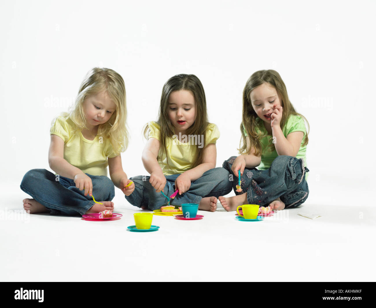 Three little girls having cake Stock Photo - Alamy