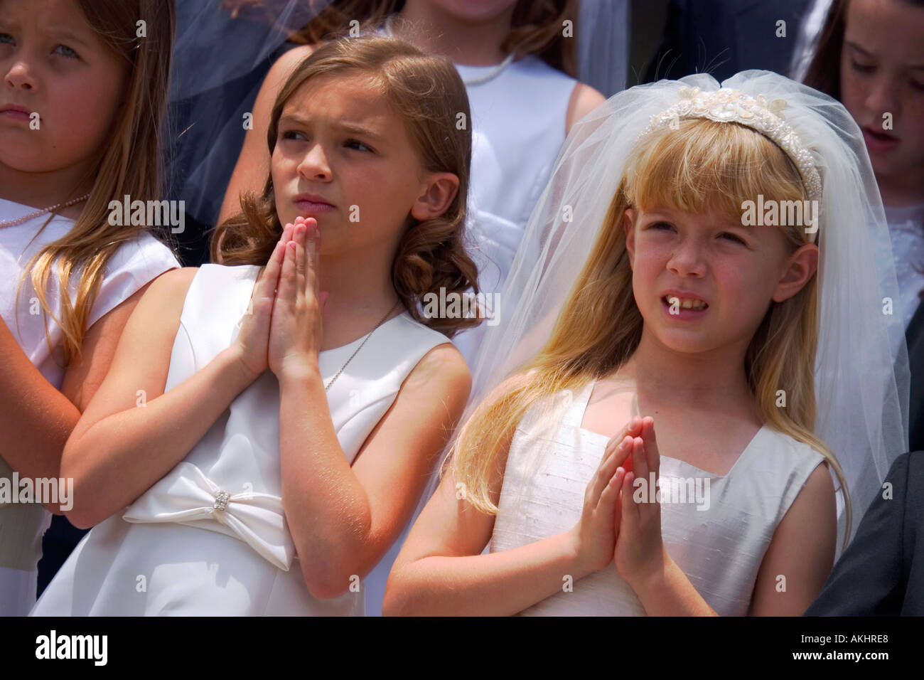Children smiling sweetly and holding their hands in prayer before ...