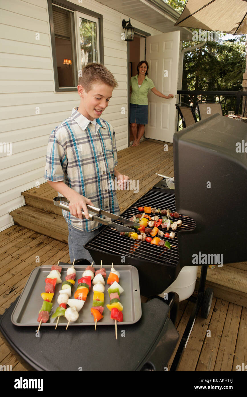 Boy barbecuing outdoors Stock Photo - Alamy