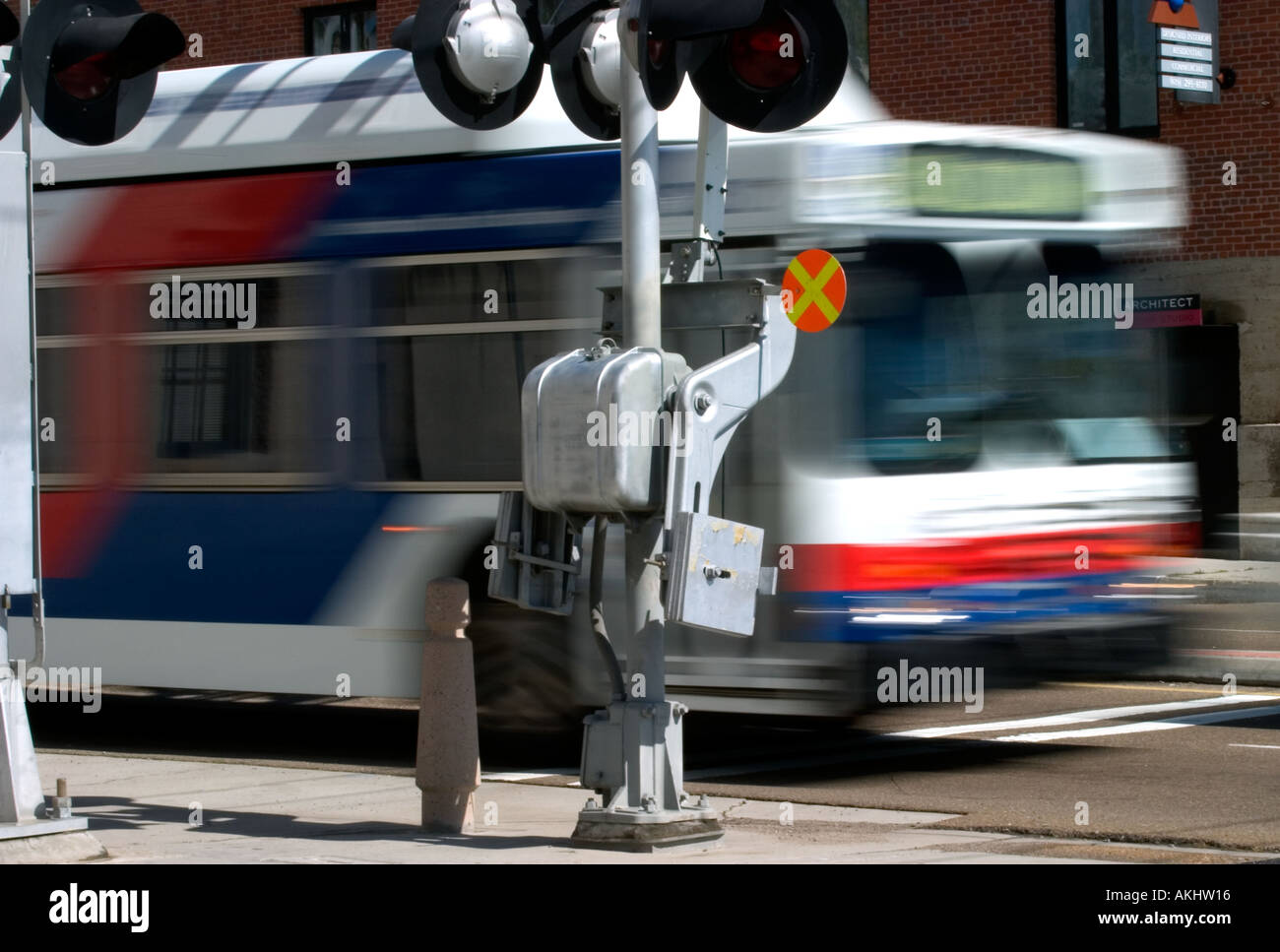 Motion blur image of a city bus as it passes a railroad crossing guard ...