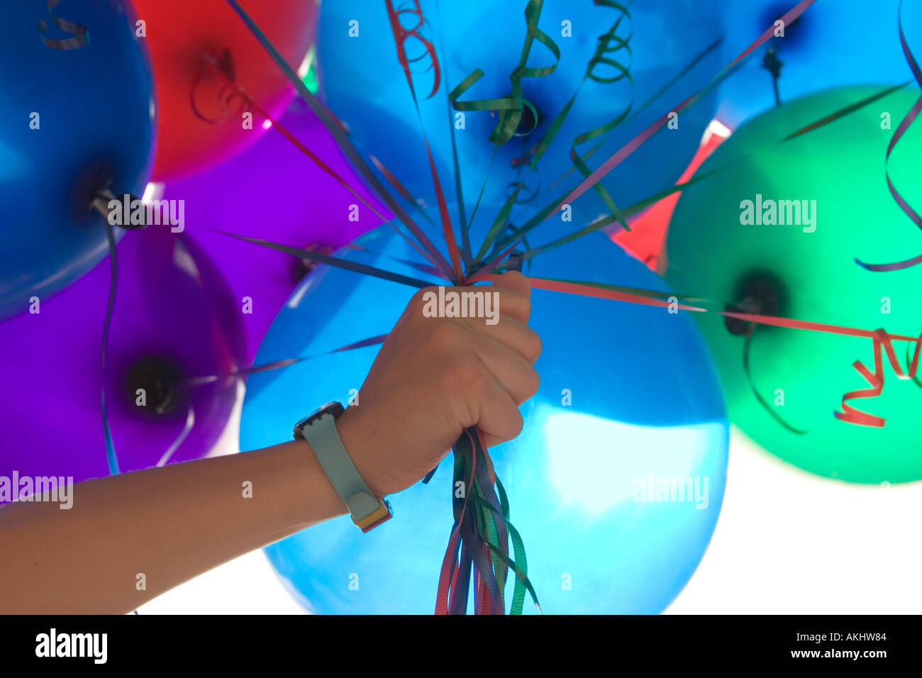 Hand holding multicolored balloons hi-res stock photography and images ...