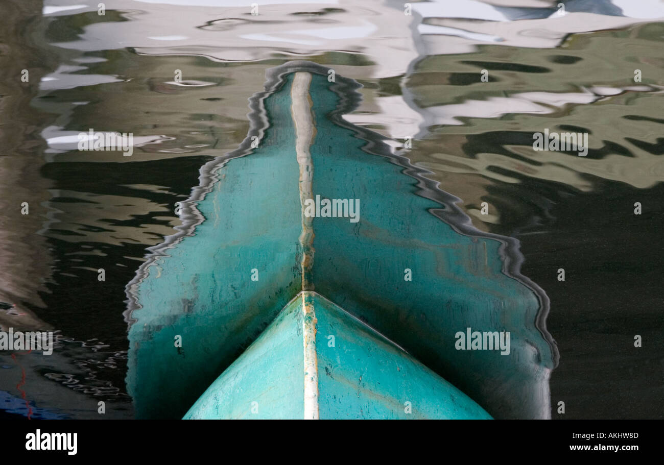 A turquoise rowboat and its reflection in the water Stock Photo - Alamy