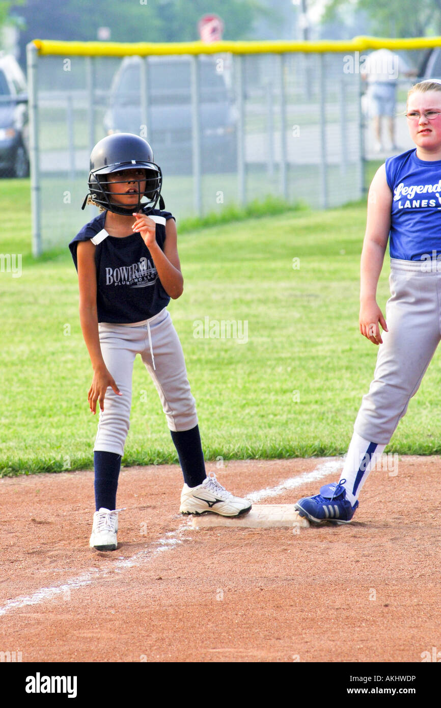 Female softball player waiting to run to third base wearing a black ...