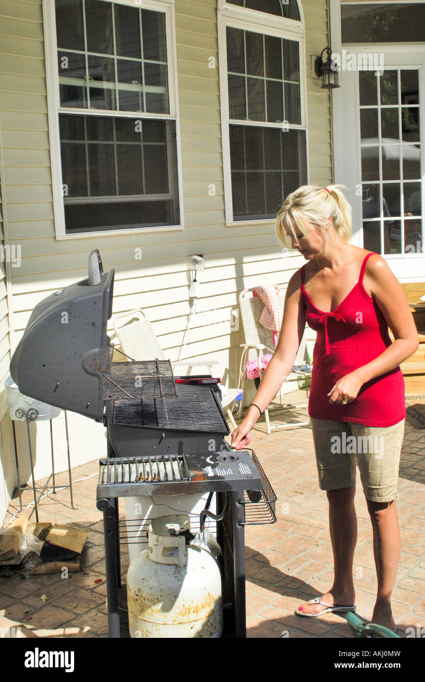 Attractive female using a bbq at a family cookout Stock Photo - Alamy