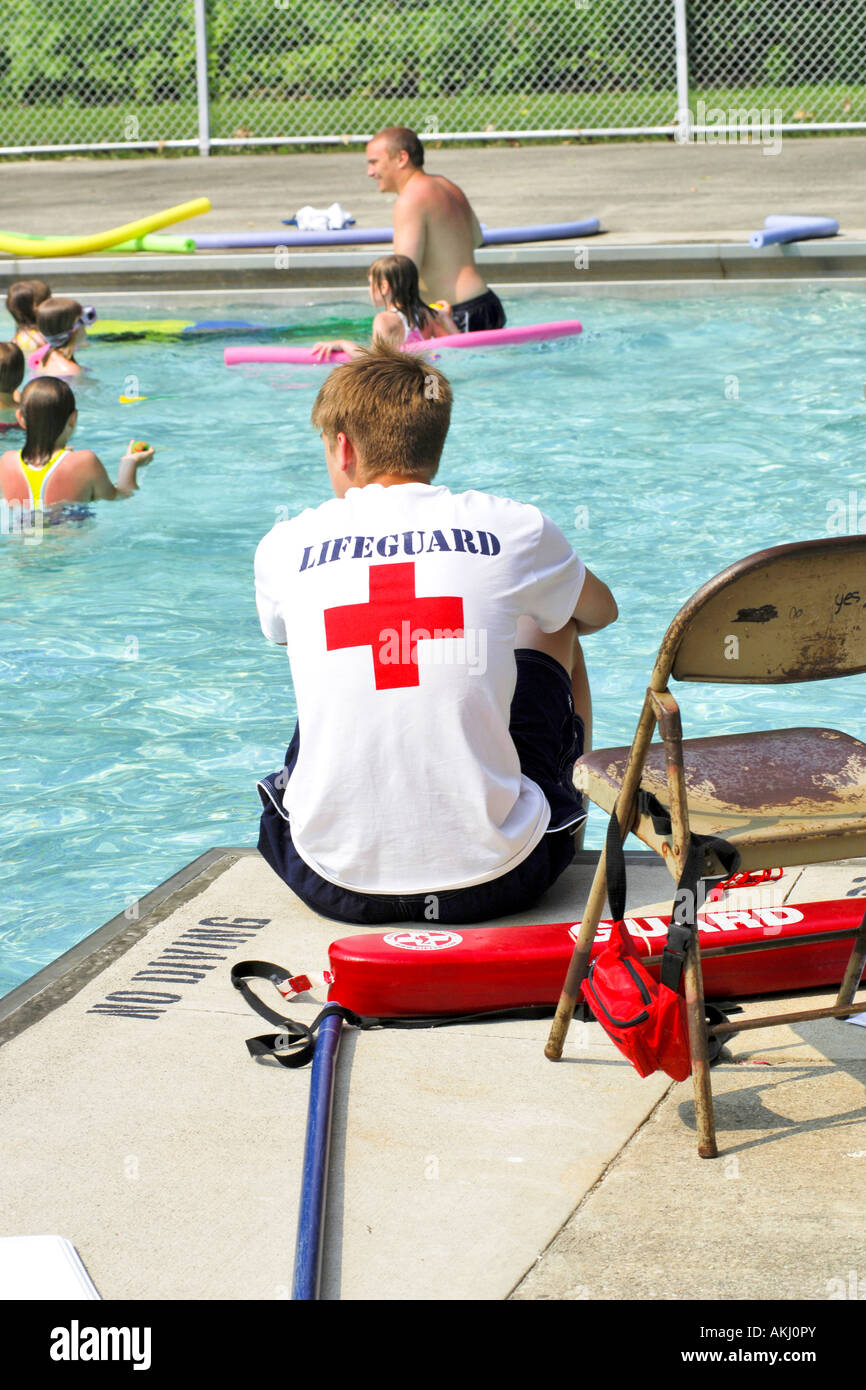 Lifeguard wearing a Red Cross T Shirt at the community swimming pool in ...