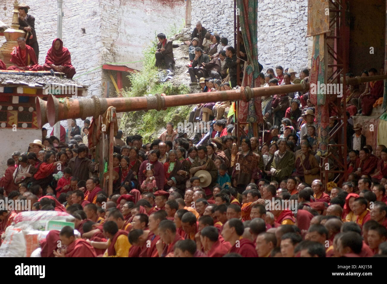 A crowd watches the Monlam Chenmo dances below a Tongchen Tibetan Horn ...