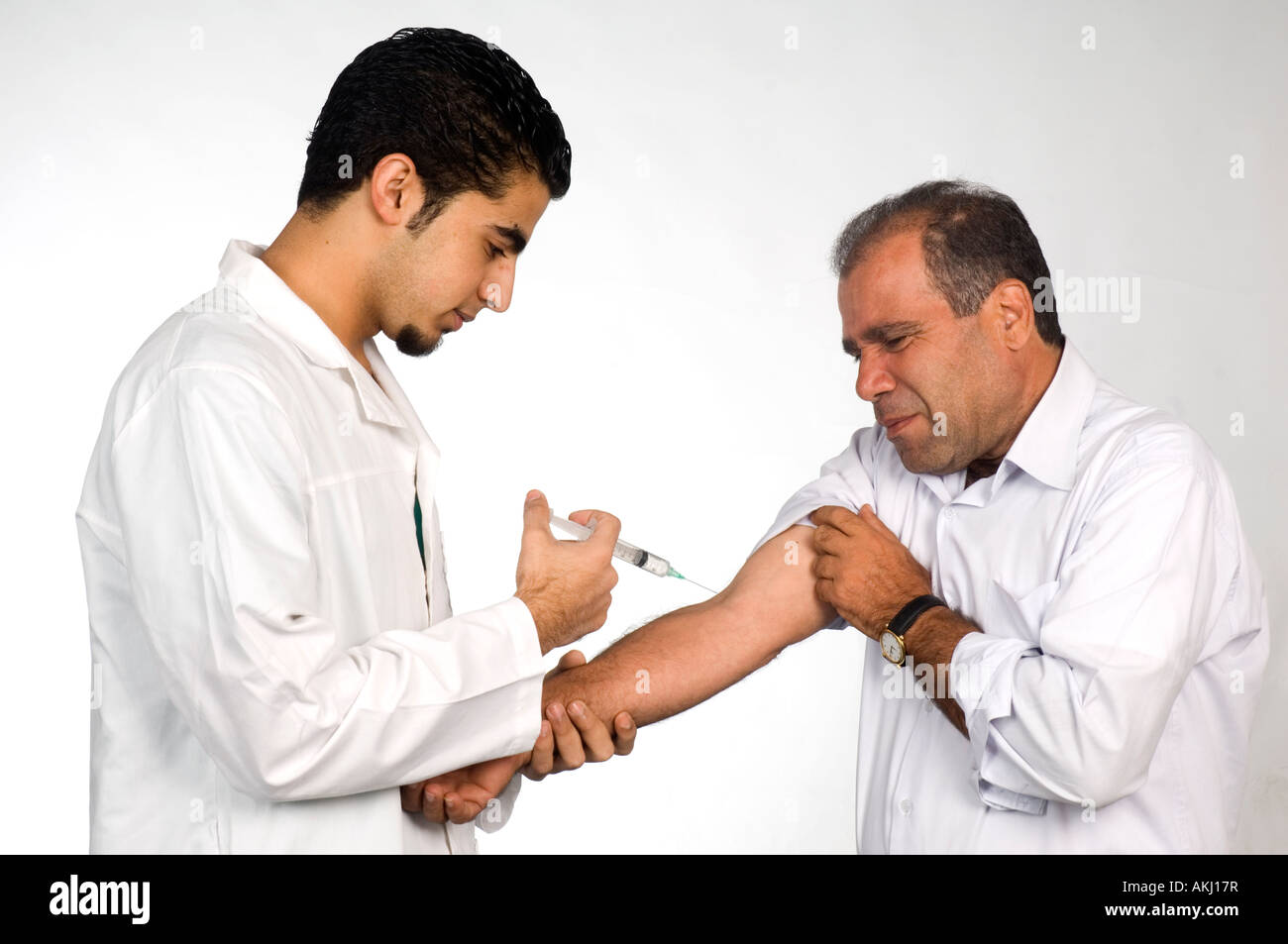 Male patient having injection from male doctor Stock Photo - Alamy