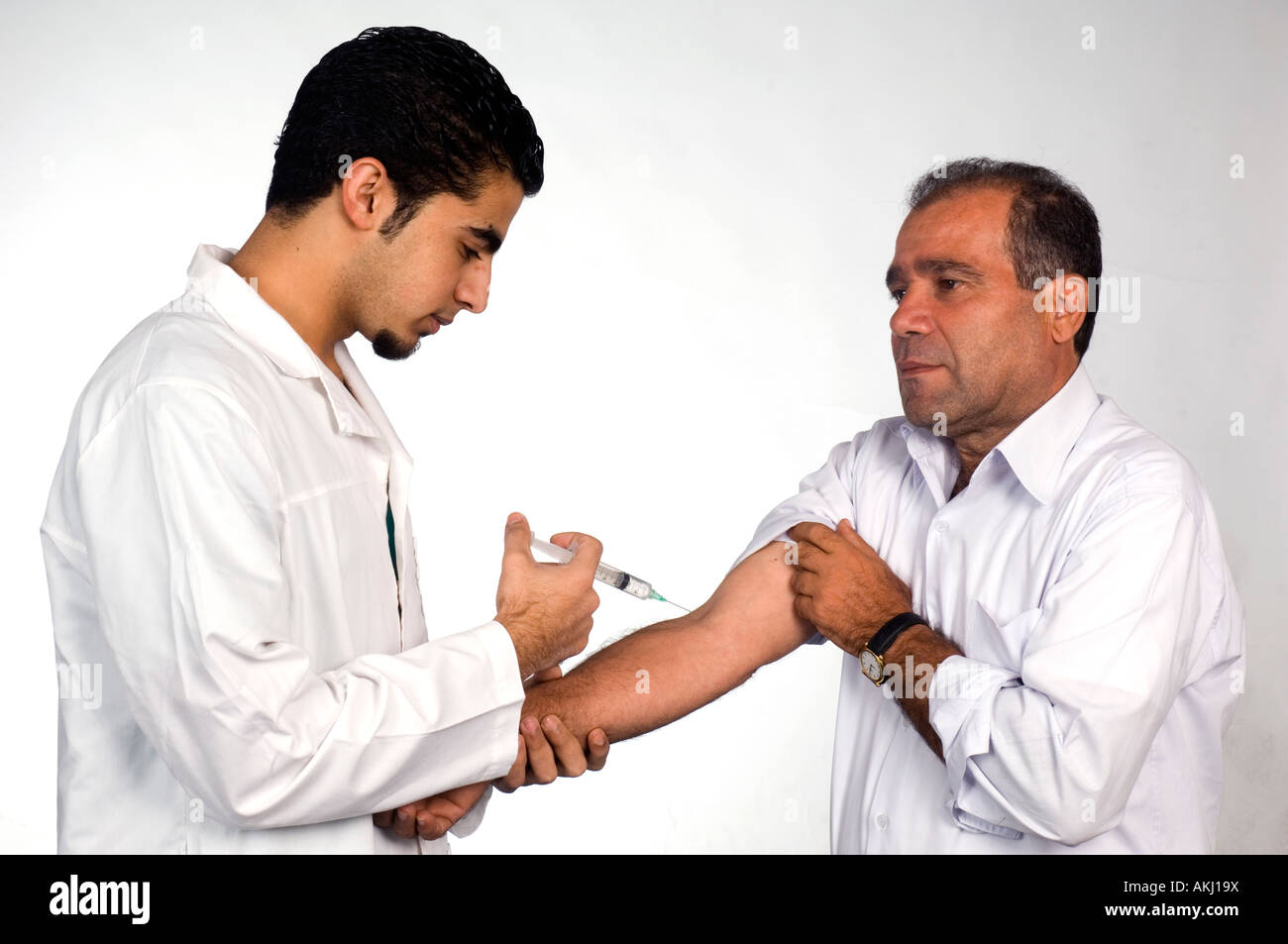 Male patient having injection from male doctor Stock Photo - Alamy