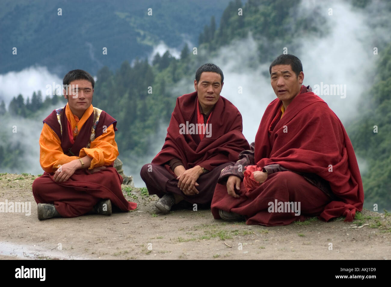 Tibetan Buddhist monks sit on the roof of Katok Dorjeden Monastery Kham ...