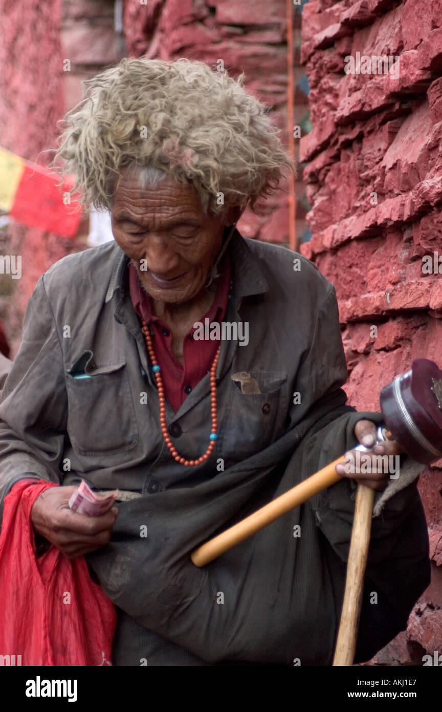 Pilgrim with bear skin hat prayer wheel at the Monlam Chenmo masked ...