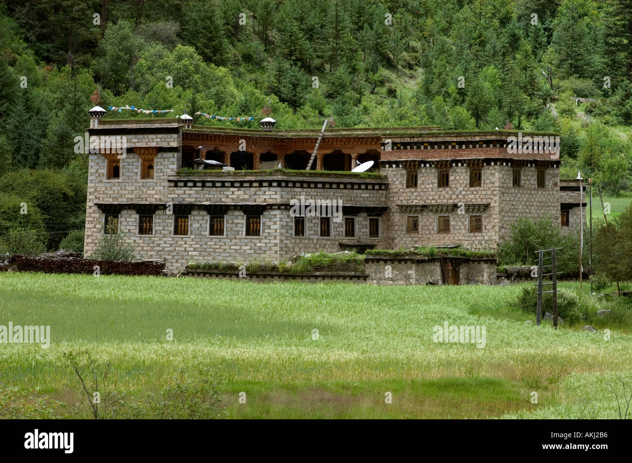Tibetan style stone house satelite dish and barley field in Dabpa ...