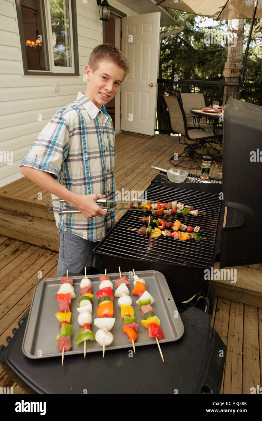 Boy barbecuing outdoors Stock Photo - Alamy