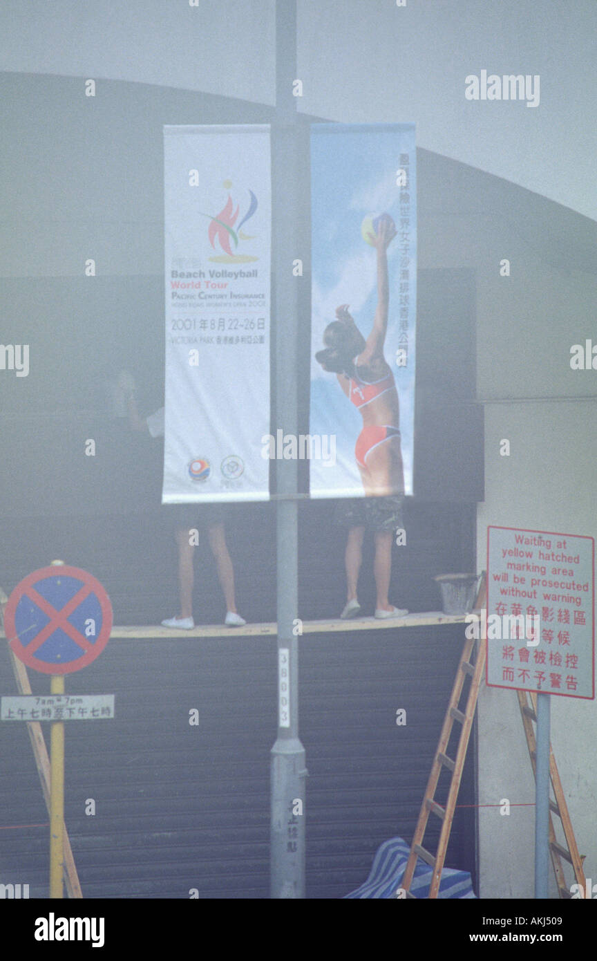 Bare legs of a man are seen behind a large sign with a womans torso ...