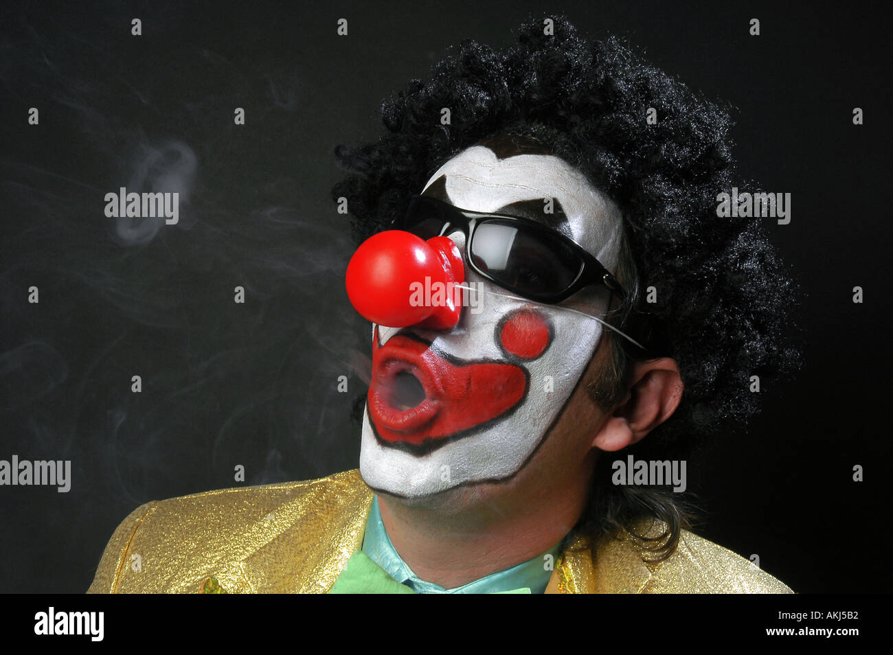 Portrait of a clown smoking and making smoke rings in the air Stock ...