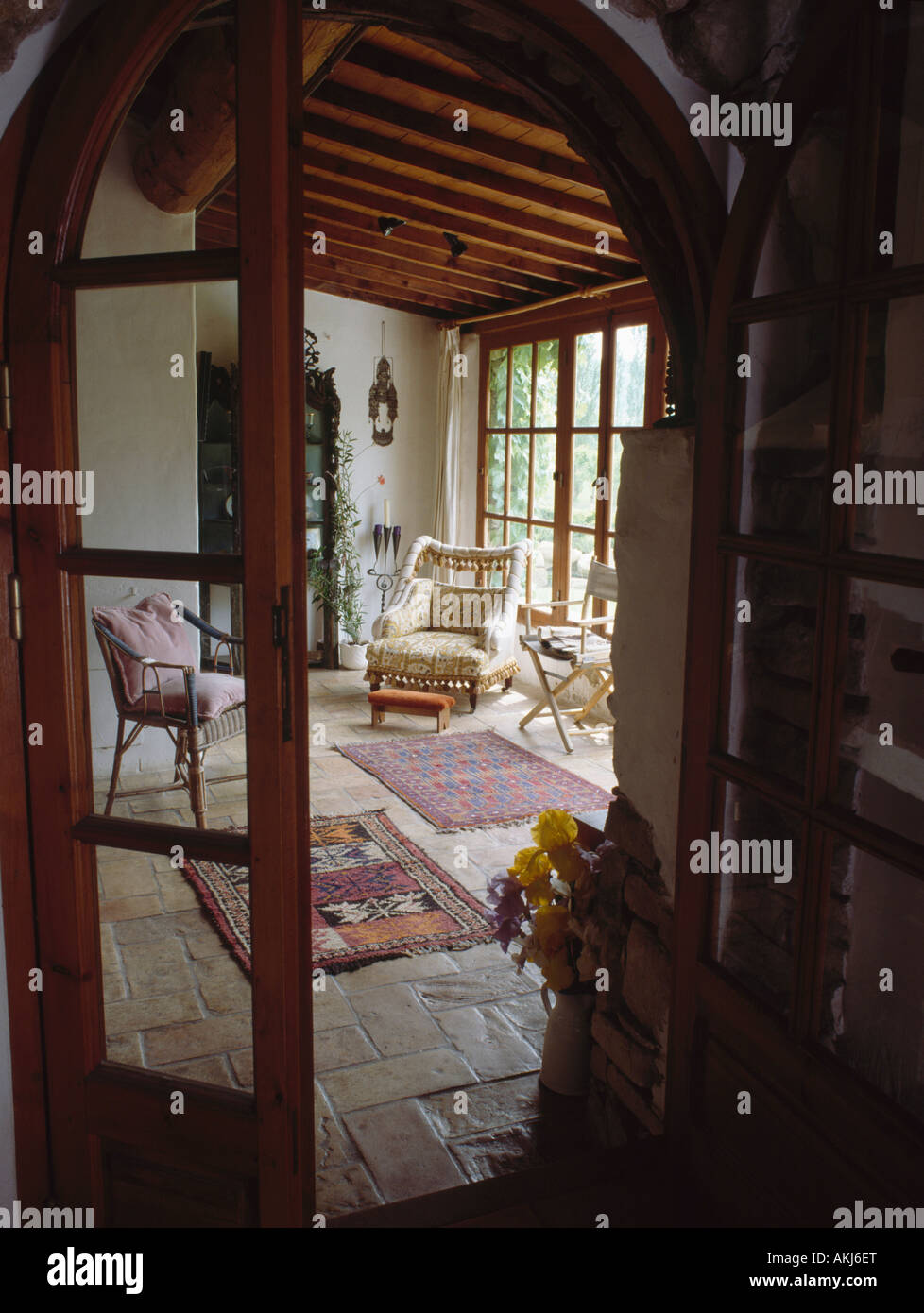 View through glazed door to cottage living room with stone flagged ...