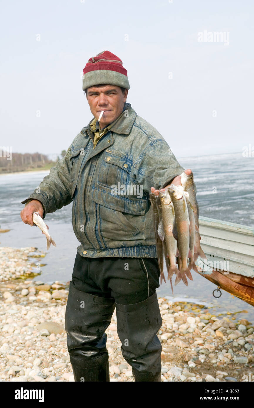 Showing his catch after fishing in the icy waters of Lake Baikal Russia ...