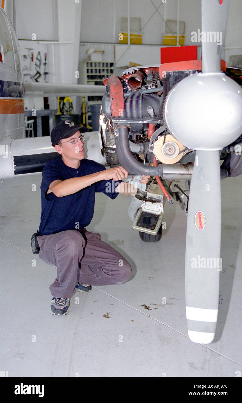 Airline mechanic works on a twin engine airplane Stock Photo - Alamy