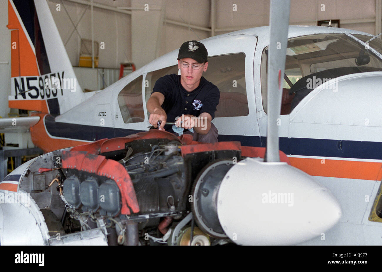 Airline mechanic works on a twin engine airplane Stock Photo - Alamy