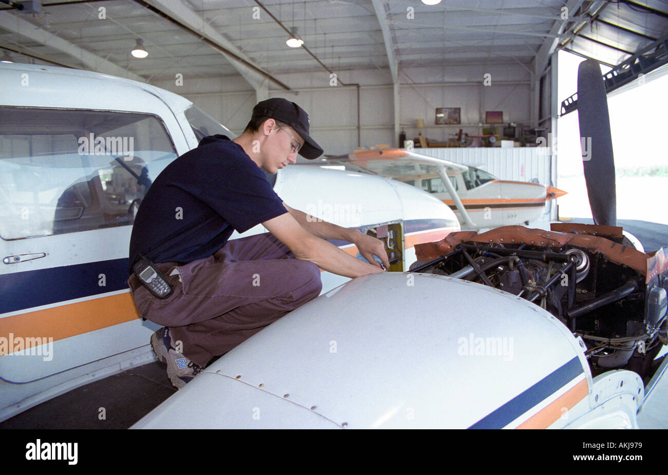 Airline mechanic works on a twin engine airplane Stock Photo - Alamy