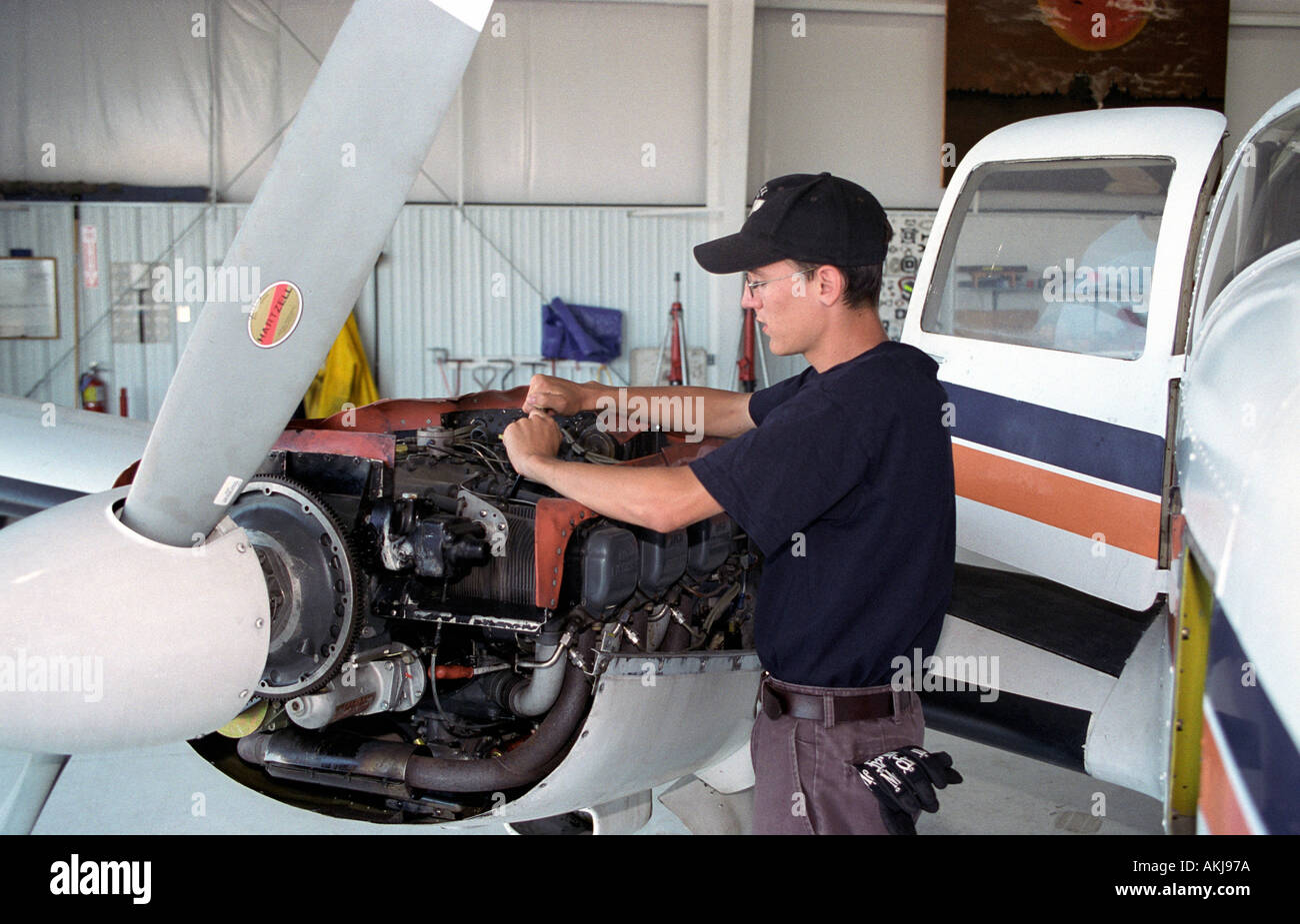 Airline mechanic works on a twin engine airplane Stock Photo - Alamy