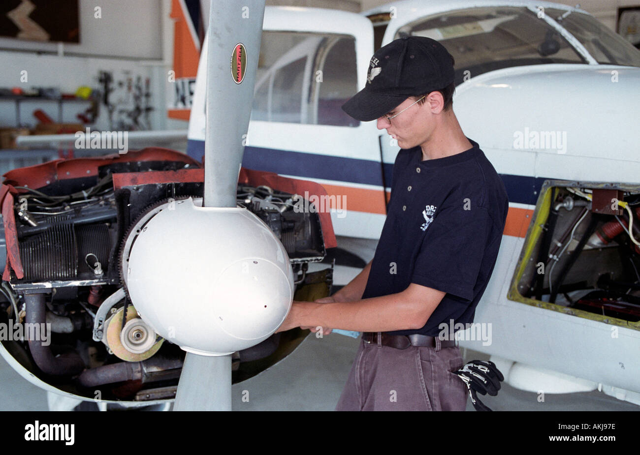 Airline mechanic works on a twin engine airplane Stock Photo - Alamy