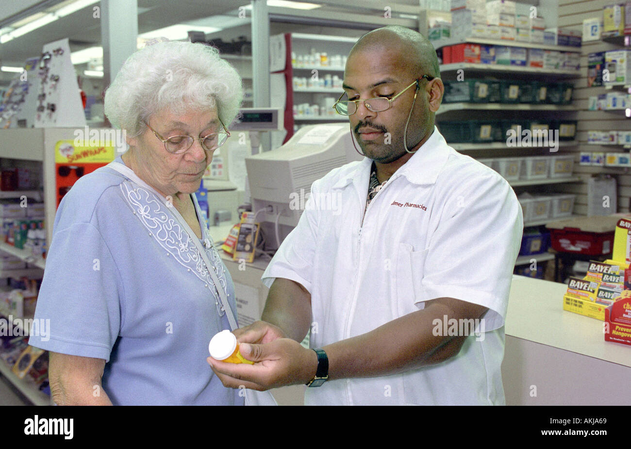 Pharmacist explains medicine to senior female patient at a pharmacy ...