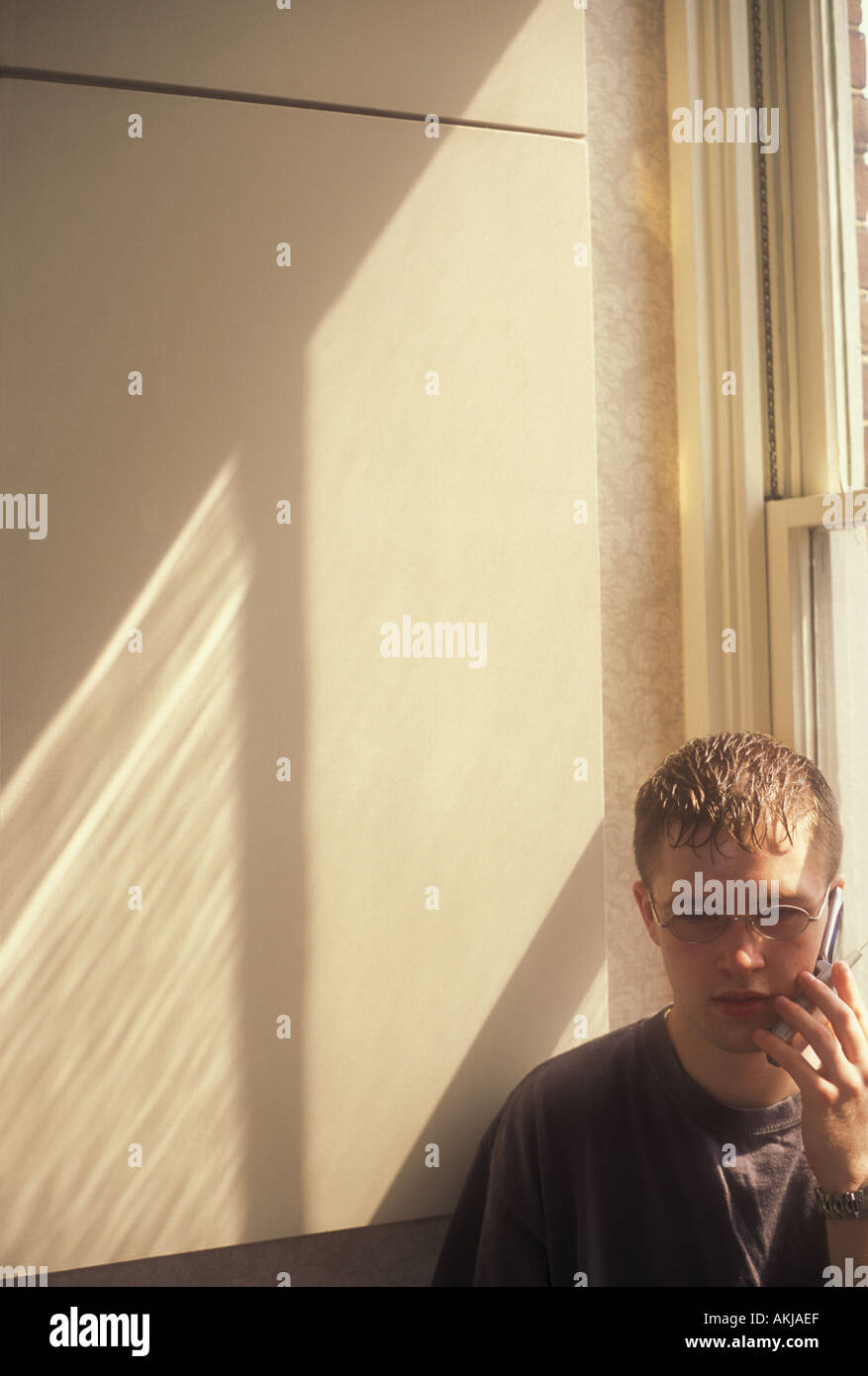 Using sitting in corner Cellphone Stock Photo - Alamy