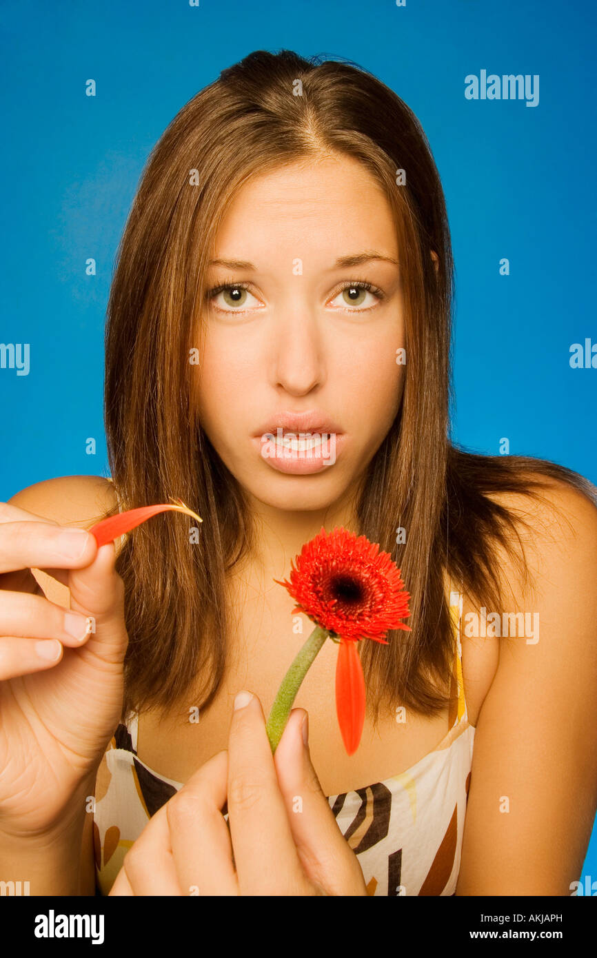 Girl pulling petals off a flower Stock Photo - Alamy