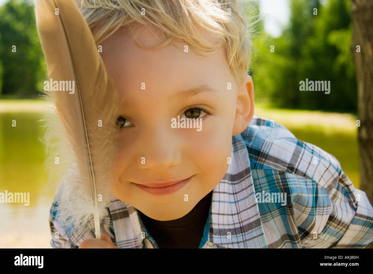 Boy holding feather Stock Photo - Alamy