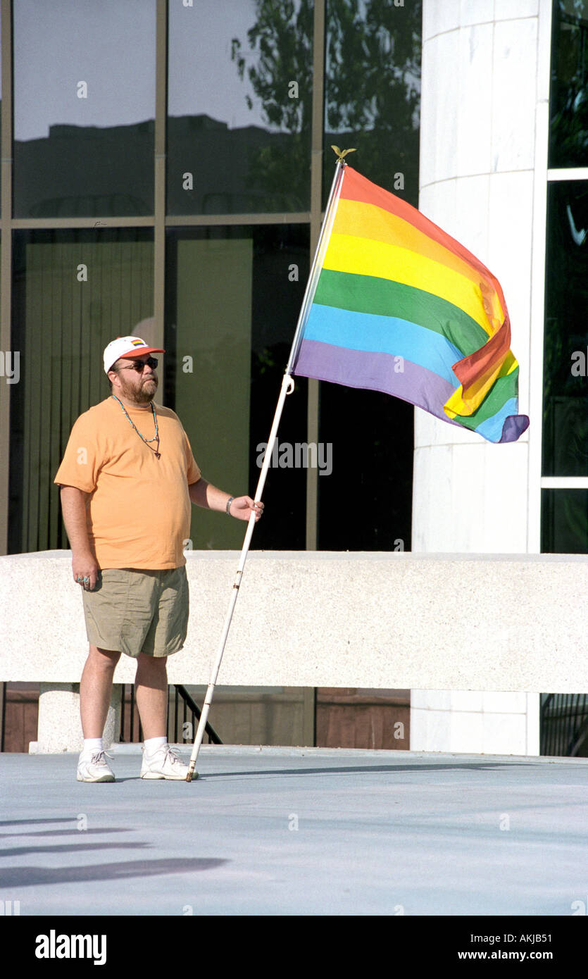 Gay partners serve as flag bearer at rally at a gay pride day event ...
