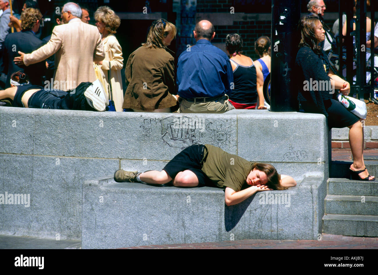 A person sleeps as city life goes on around them Stock Photo - Alamy