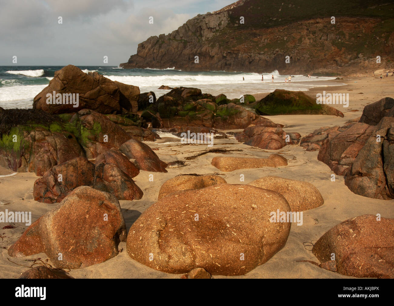Waves breaking on a Cornish beach as the setting sun casts a golden ...