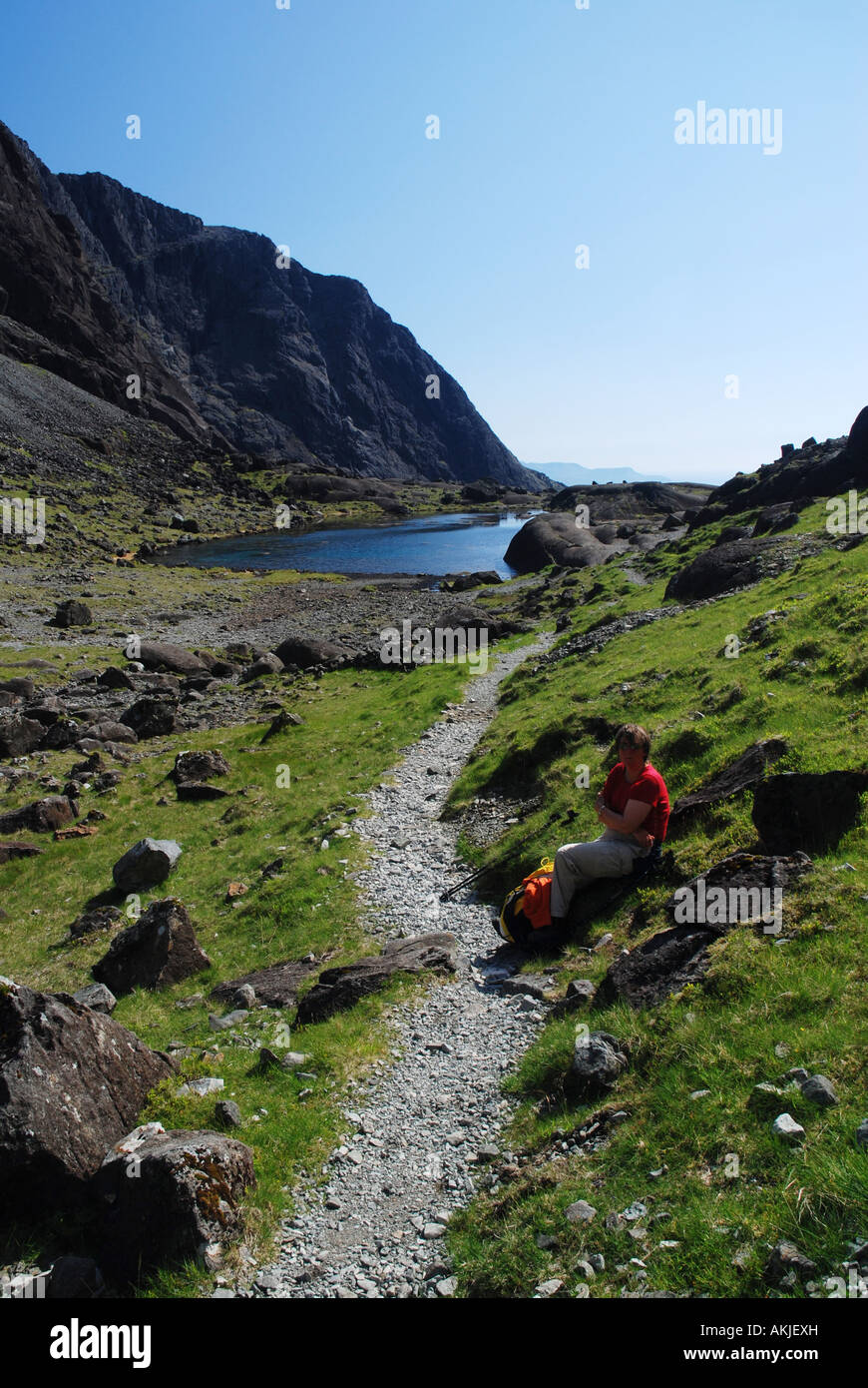 Hiker resting Coire Lagan valley, Loch an Fhir Bhallaich, Cuillin hills ...