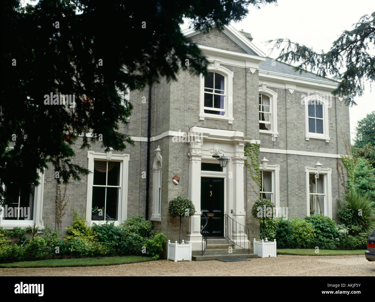 Detached Victorian country house with bay trees in containers on either ...