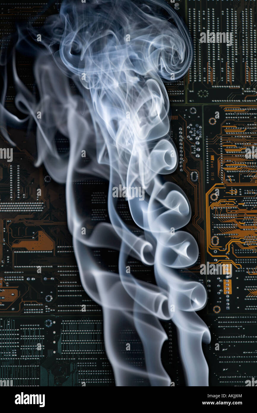 Smoke over a computer circuit board indicating overworked computers ...
