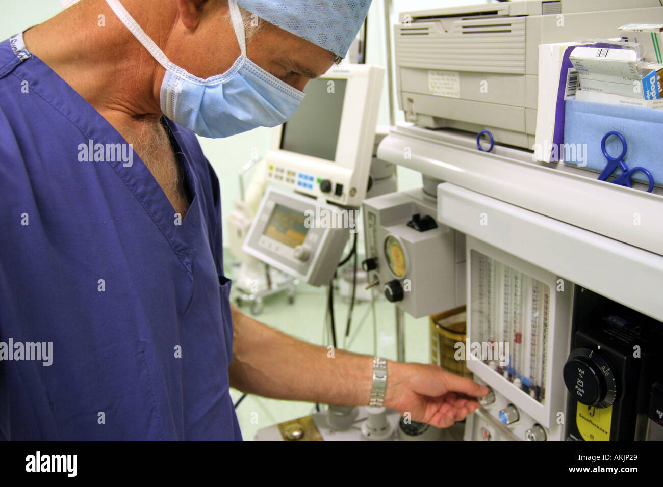 Male anaesthetist checking gas flow rates on an anaesthetic machine ...