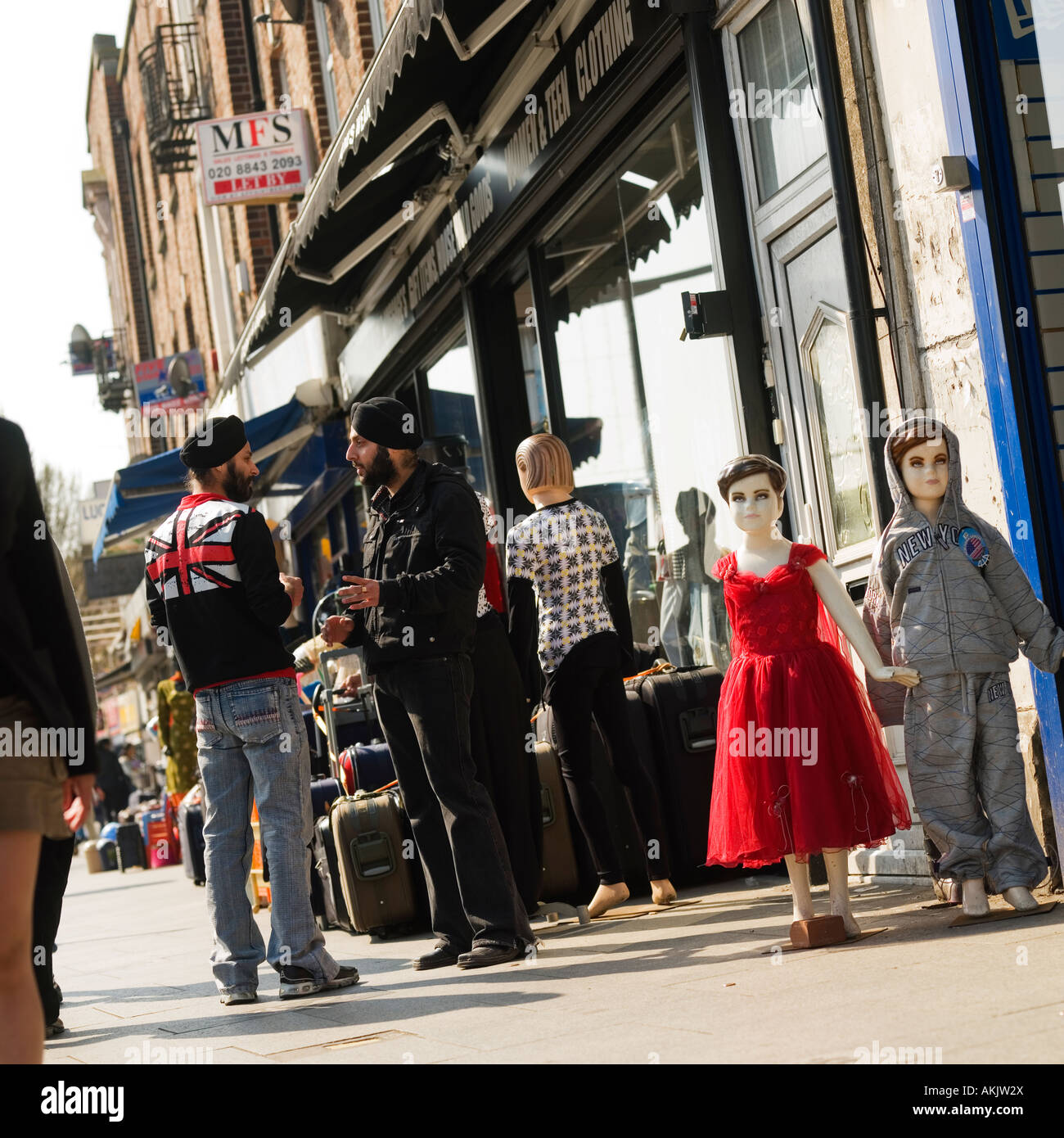 Sikh shopkeeper talking outside his store surrounded by mannequins of ...