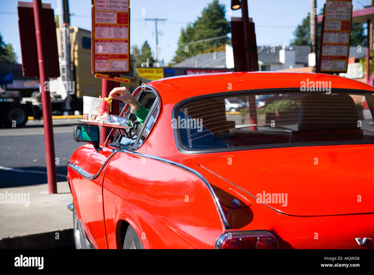 Reaching through sports car window at drive in Stock Photo - Alamy