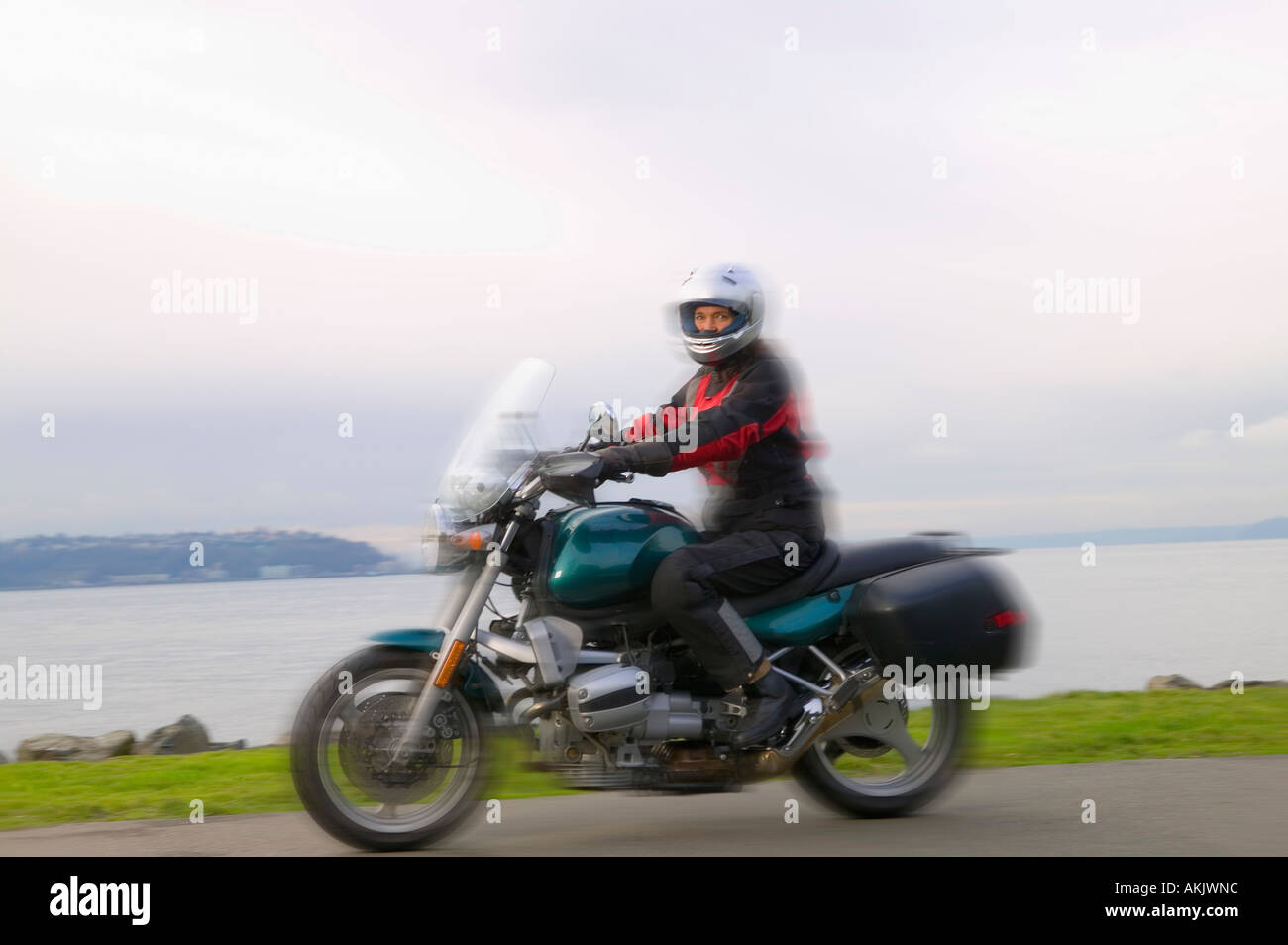 Woman riding motorcycle on coastal road Stock Photo - Alamy