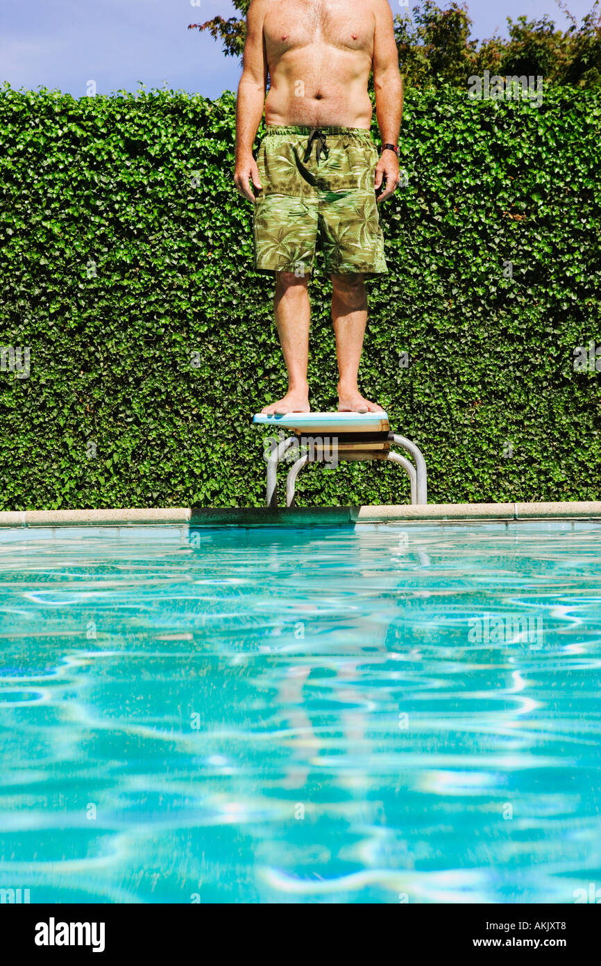 Man standing on swimming pool diving board Stock Photo - Alamy